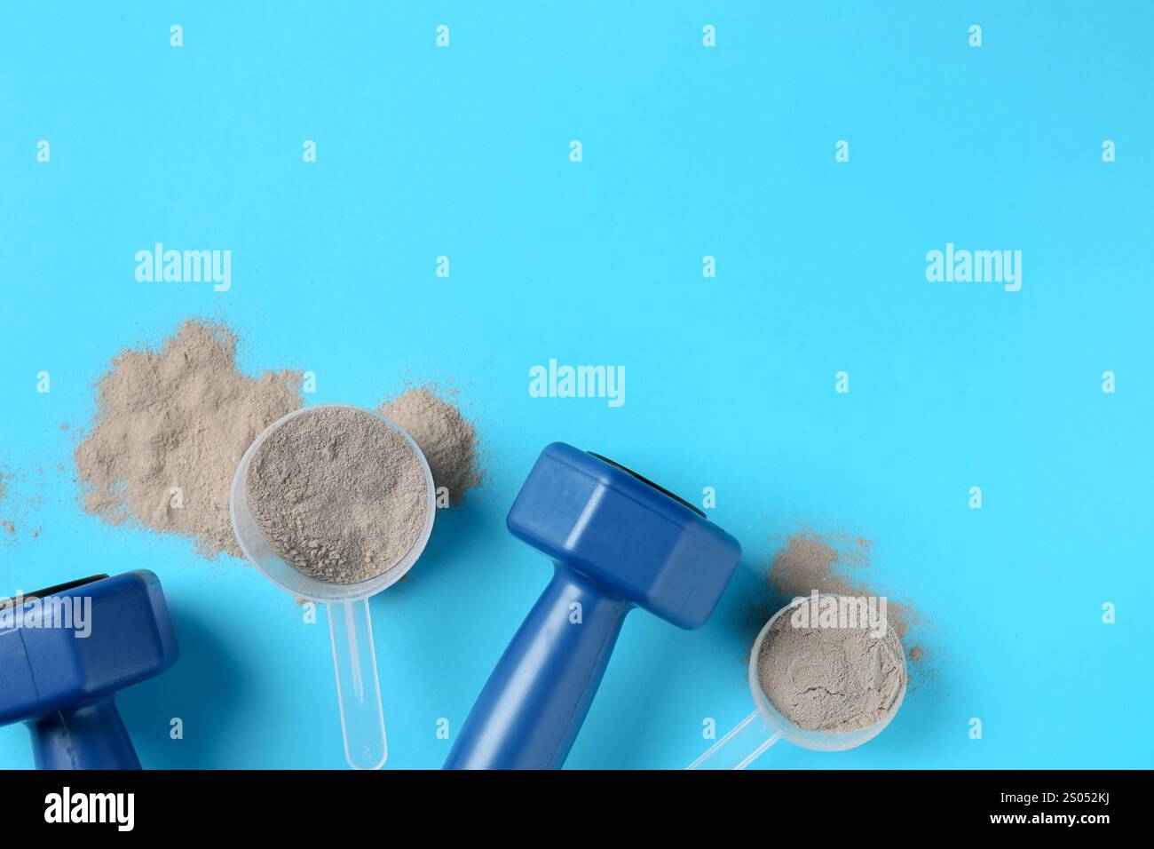 Protein powder, scoops and dumbbells on light blue background, flat lay ...