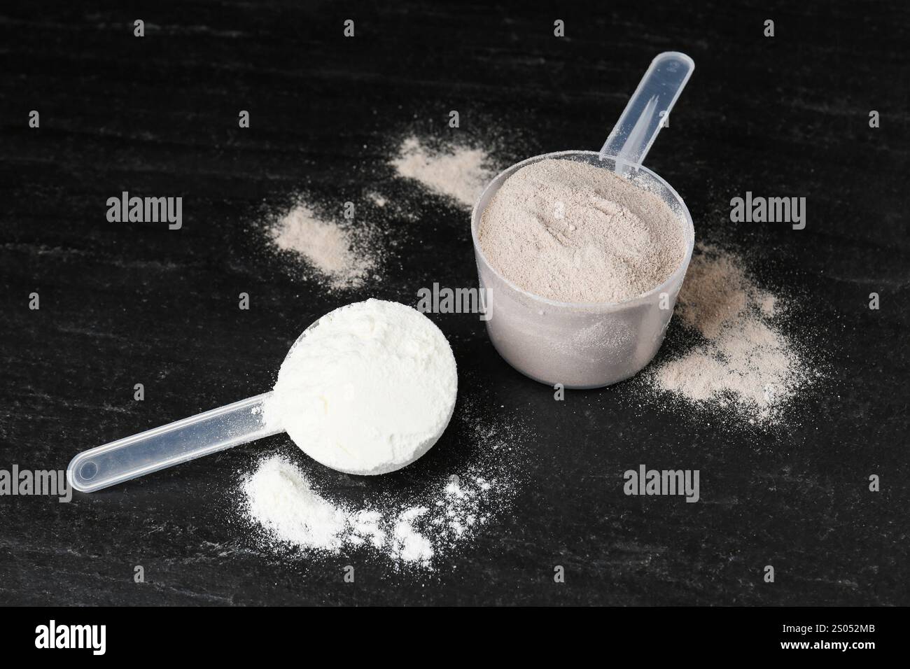 Protein powders in scoops on dark textured table Stock Photo - Alamy