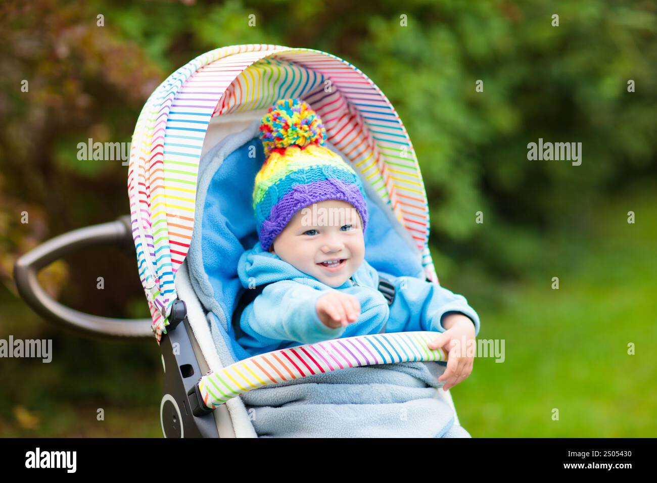 Baby in stroller on a walk in autumn park. Adorable little boy with ...