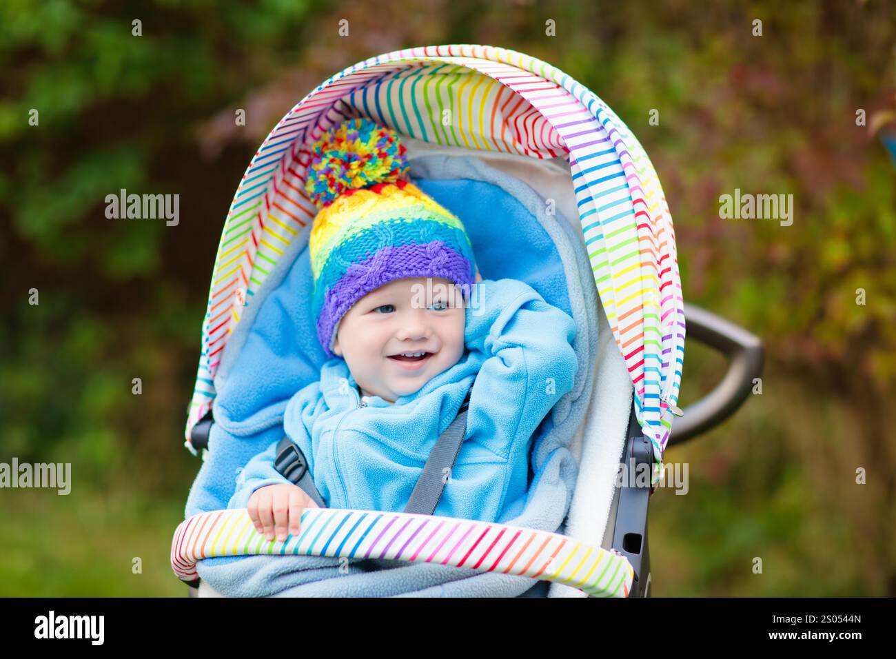 Baby in stroller on a walk in autumn park. Adorable little boy with ...