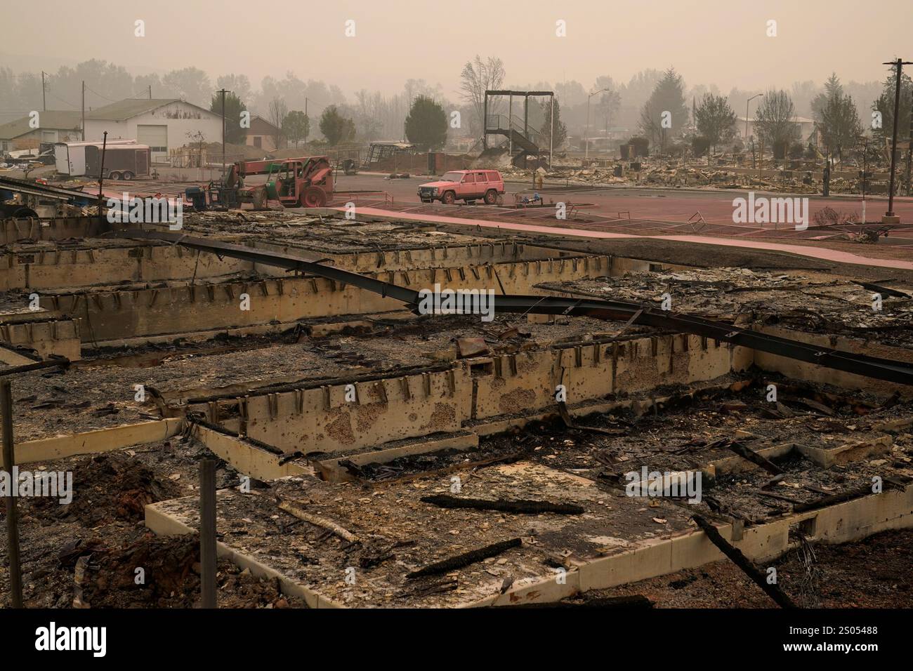 FILE - Pink fire retardant covers a car at an area destroyed by the ...
