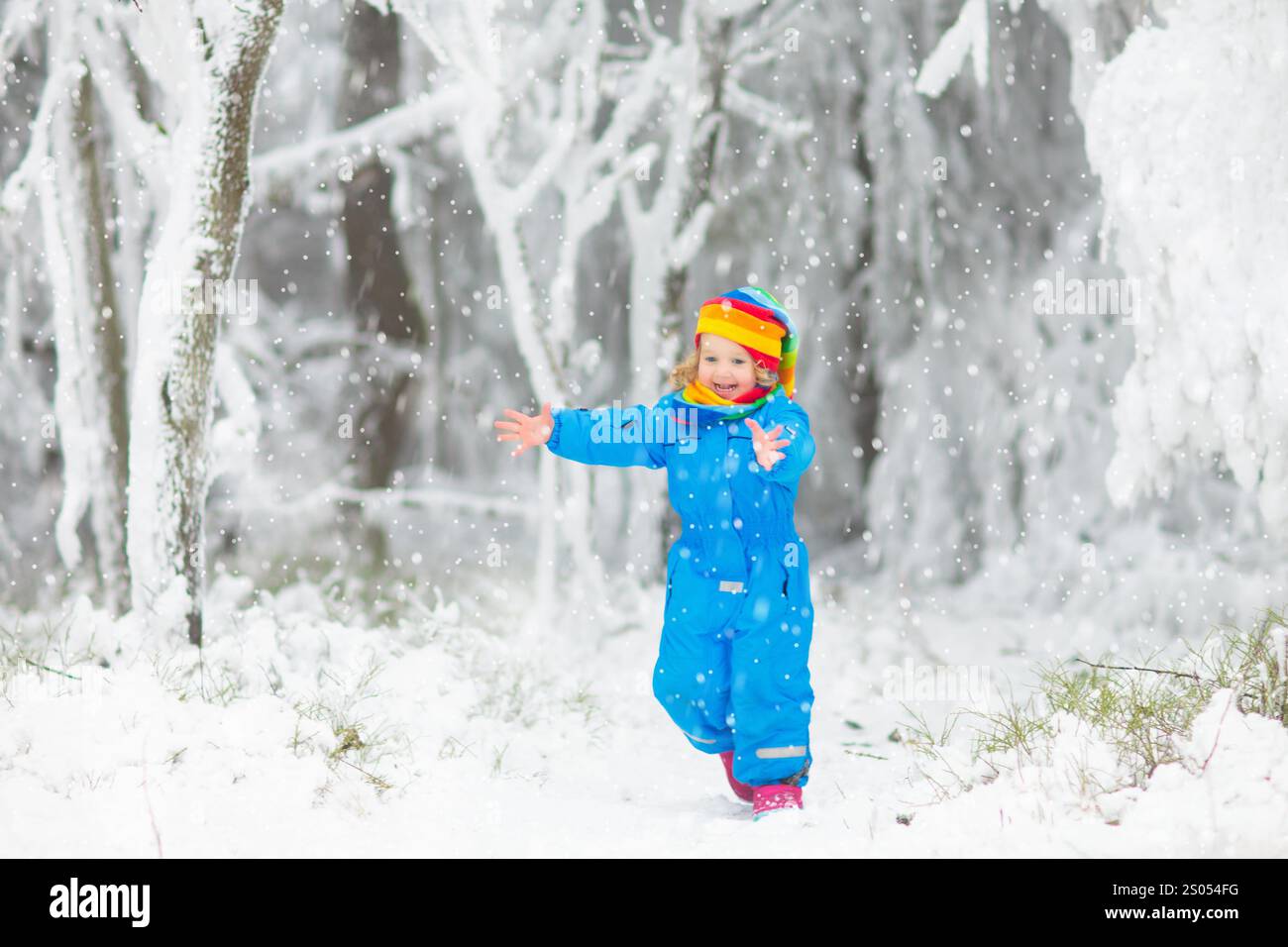 Kids play in snow in winter park. Children playing outdoors on snowy ...