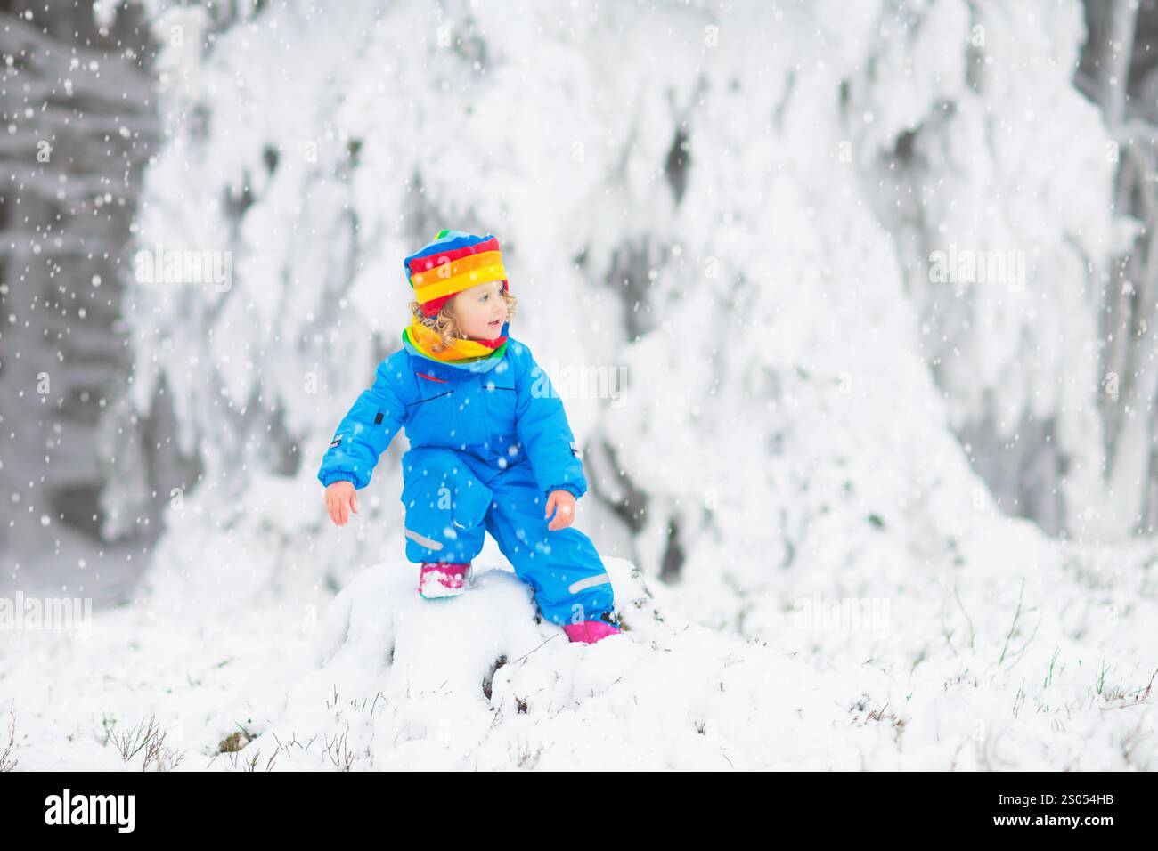 Kids play in snow in winter park. Children playing outdoors on snowy ...