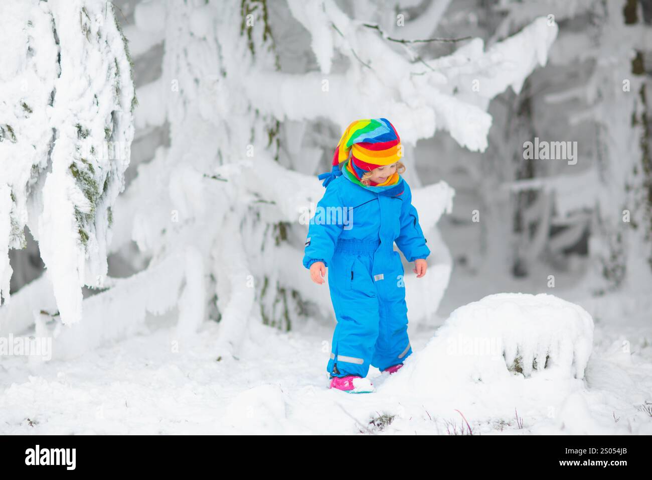 Kids play in snow in winter park. Children playing outdoors on snowy ...