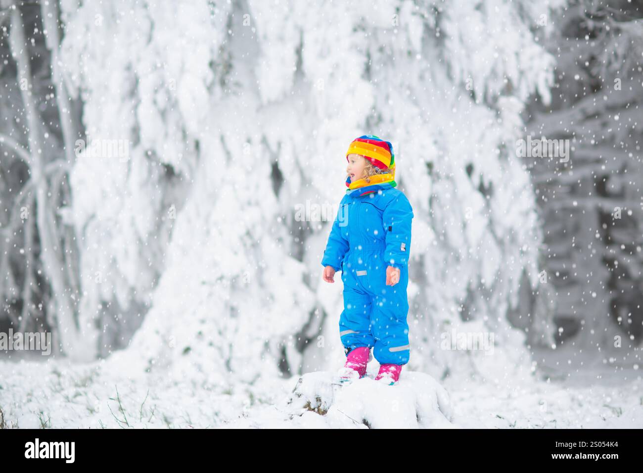 Kids play in snow in winter park. Children playing outdoors on snowy ...