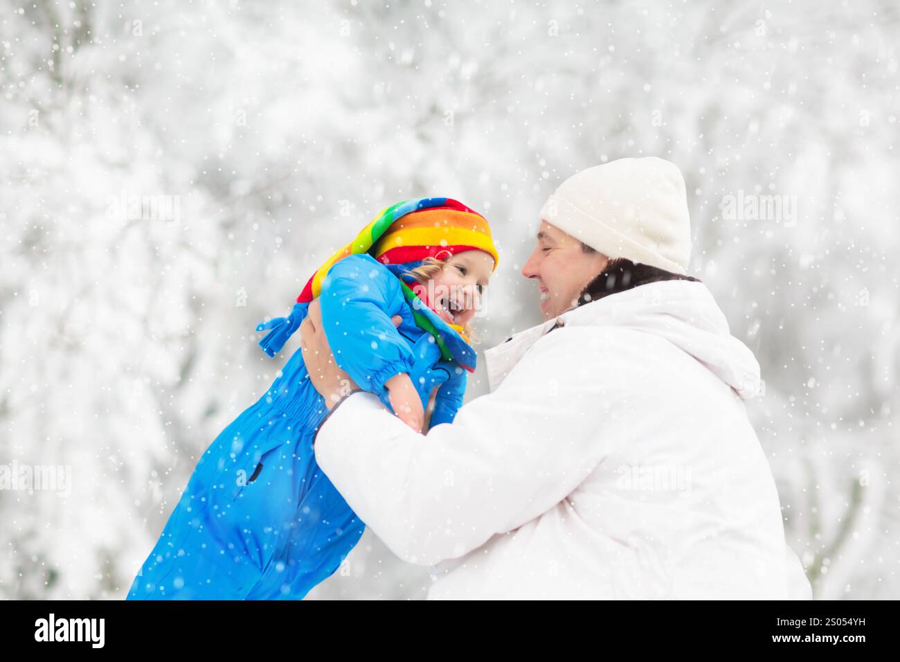 Kids play in snow in winter park. Children playing outdoors on snowy ...