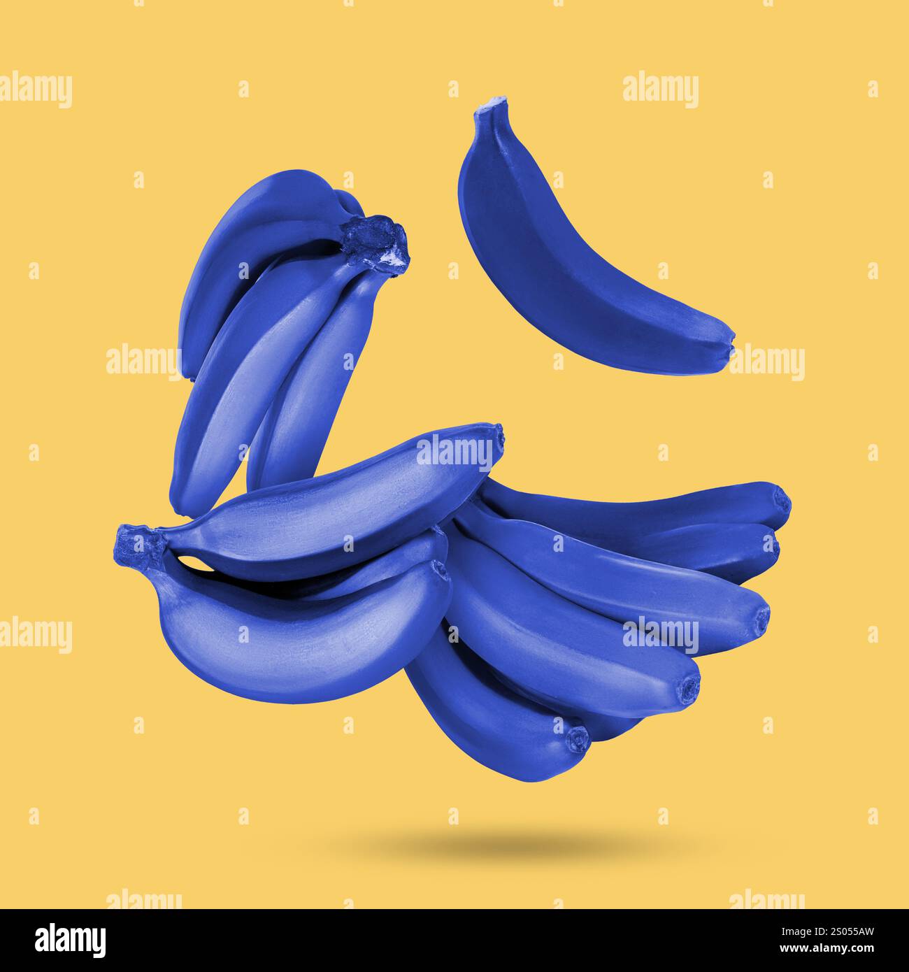 Blue bananas in air on light orange background Stock Photo - Alamy