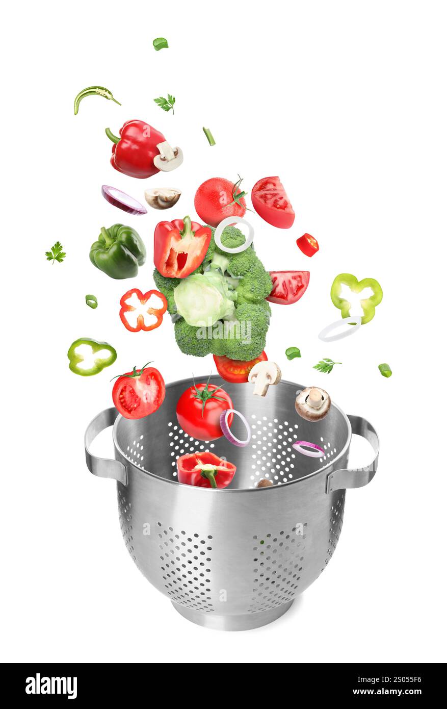 Different fresh vegetables falling into colander on white background ...