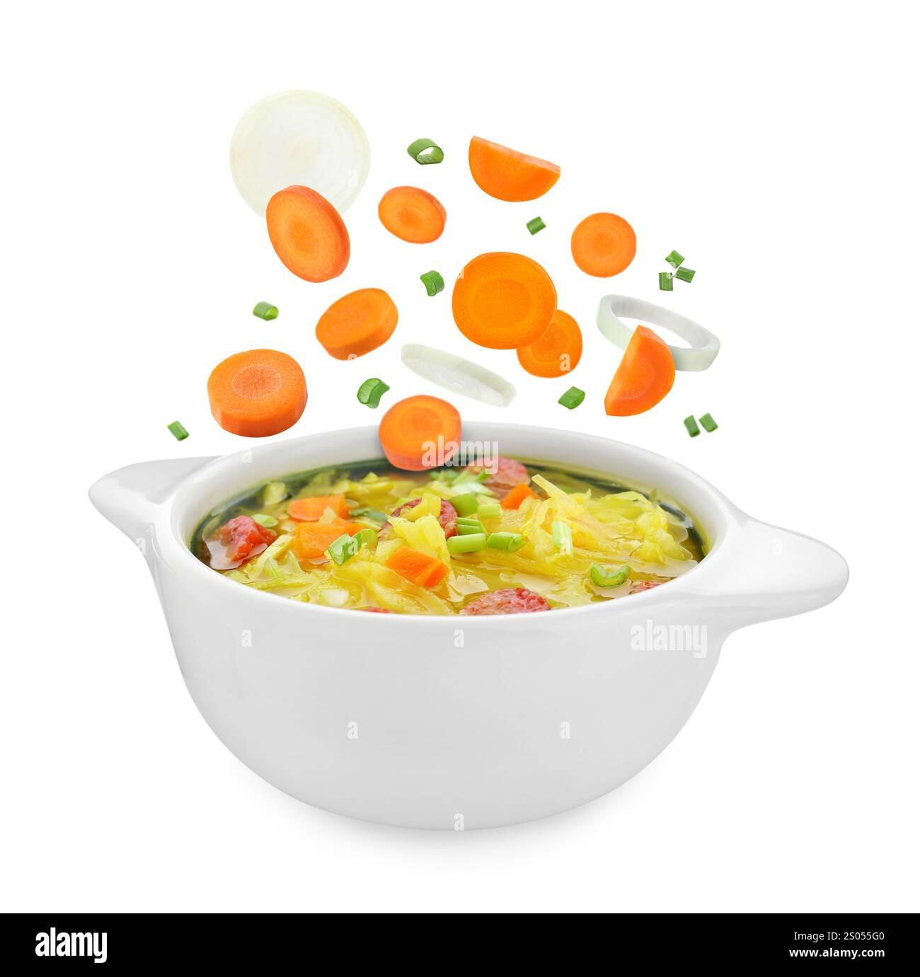 Vegetables falling into pot with soup on white background Stock Photo ...