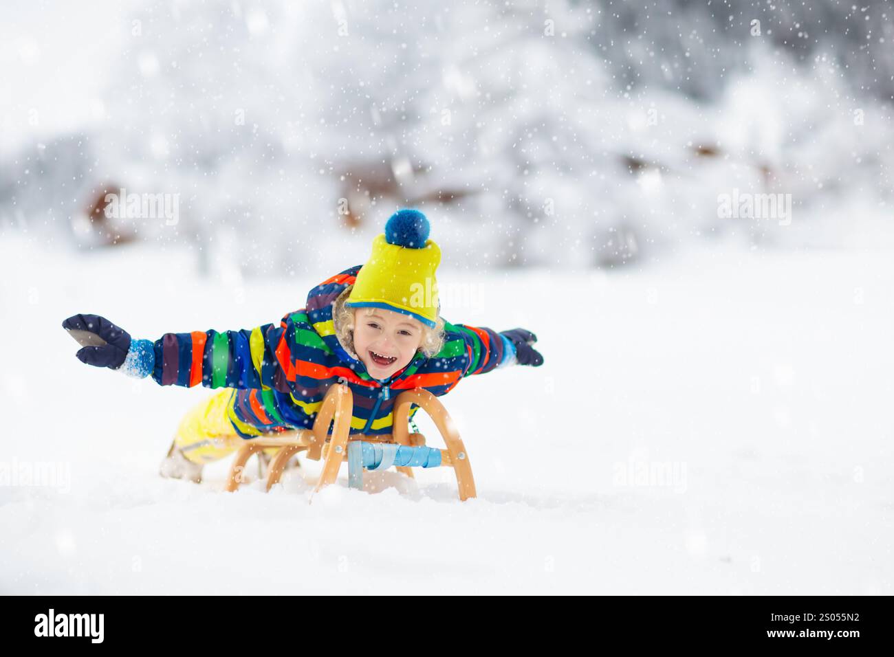 Little boy enjoying a sleigh ride. Child sledding. Toddler kid riding a ...