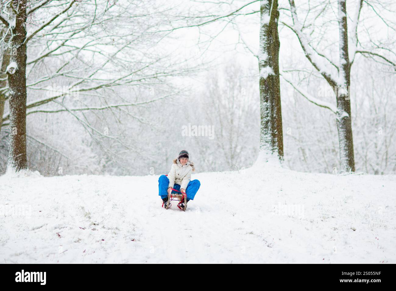 Kids play in snow in winter park. Children playing outdoors on snowy ...