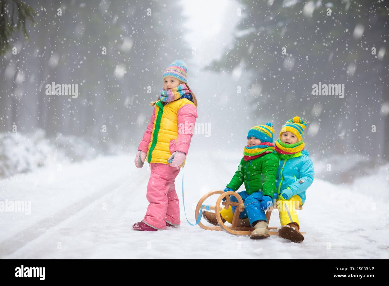 Kids play in snow in winter park. Children playing outdoors on snowy ...