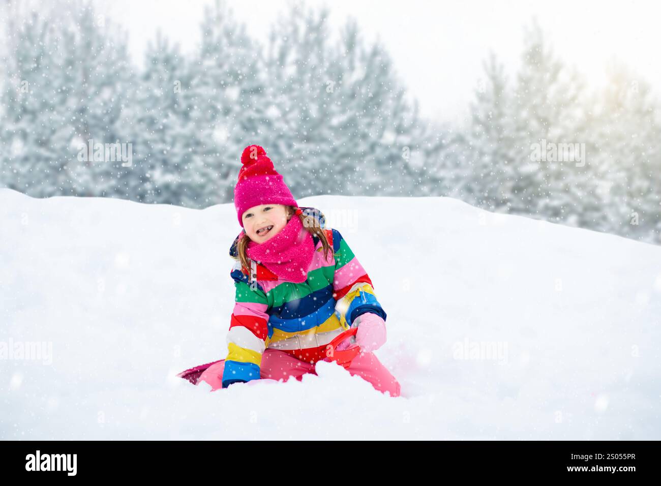 Little girl enjoying a sleigh ride. Child sledding. Toddler kid riding ...