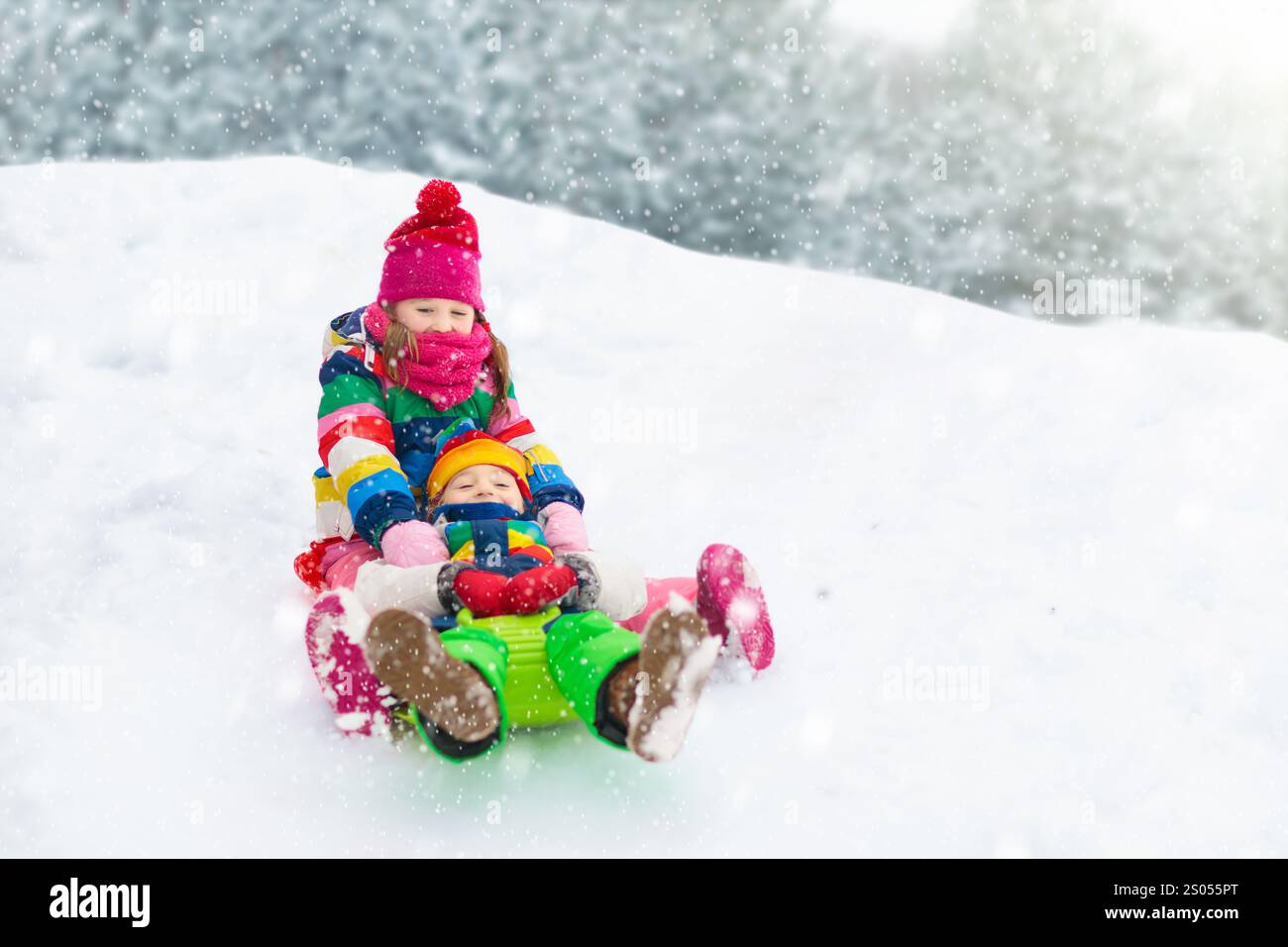 Kids play in snow in winter park. Children playing outdoors on snowy ...