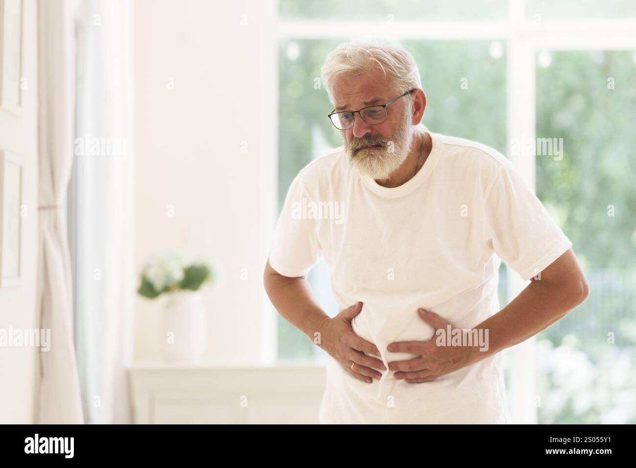 Senior man in pain. Retired man suffering from chest, back and stomach ...