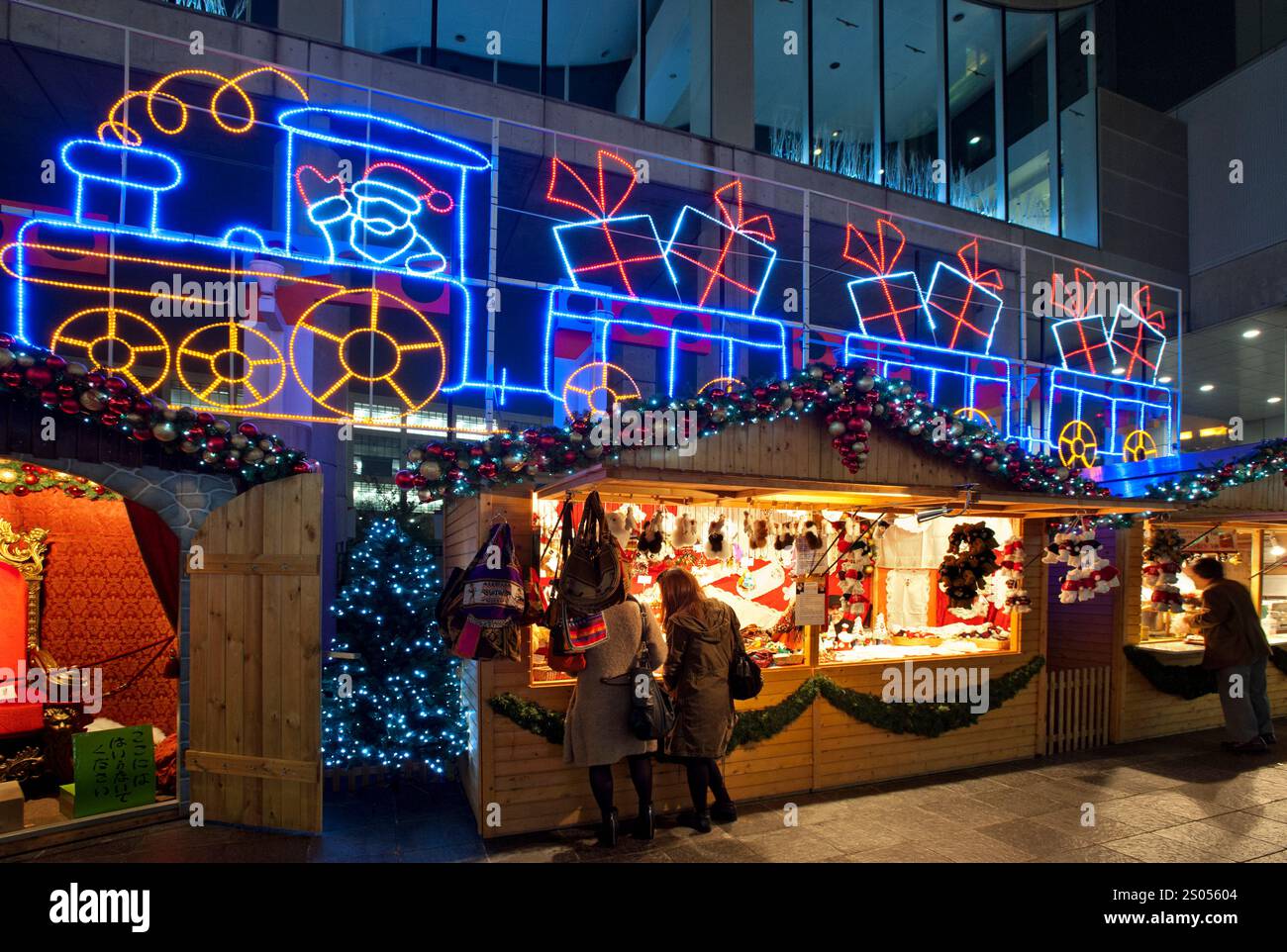 A festive German Christmas market with illumination and gift shops seen ...