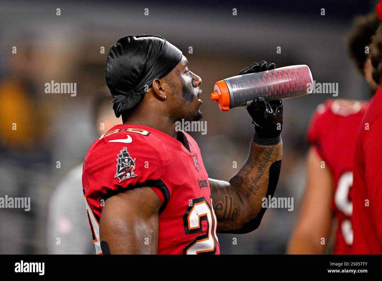 Tampa Bay Buccaneers safety Christian Izien drinks from a water bottle ...