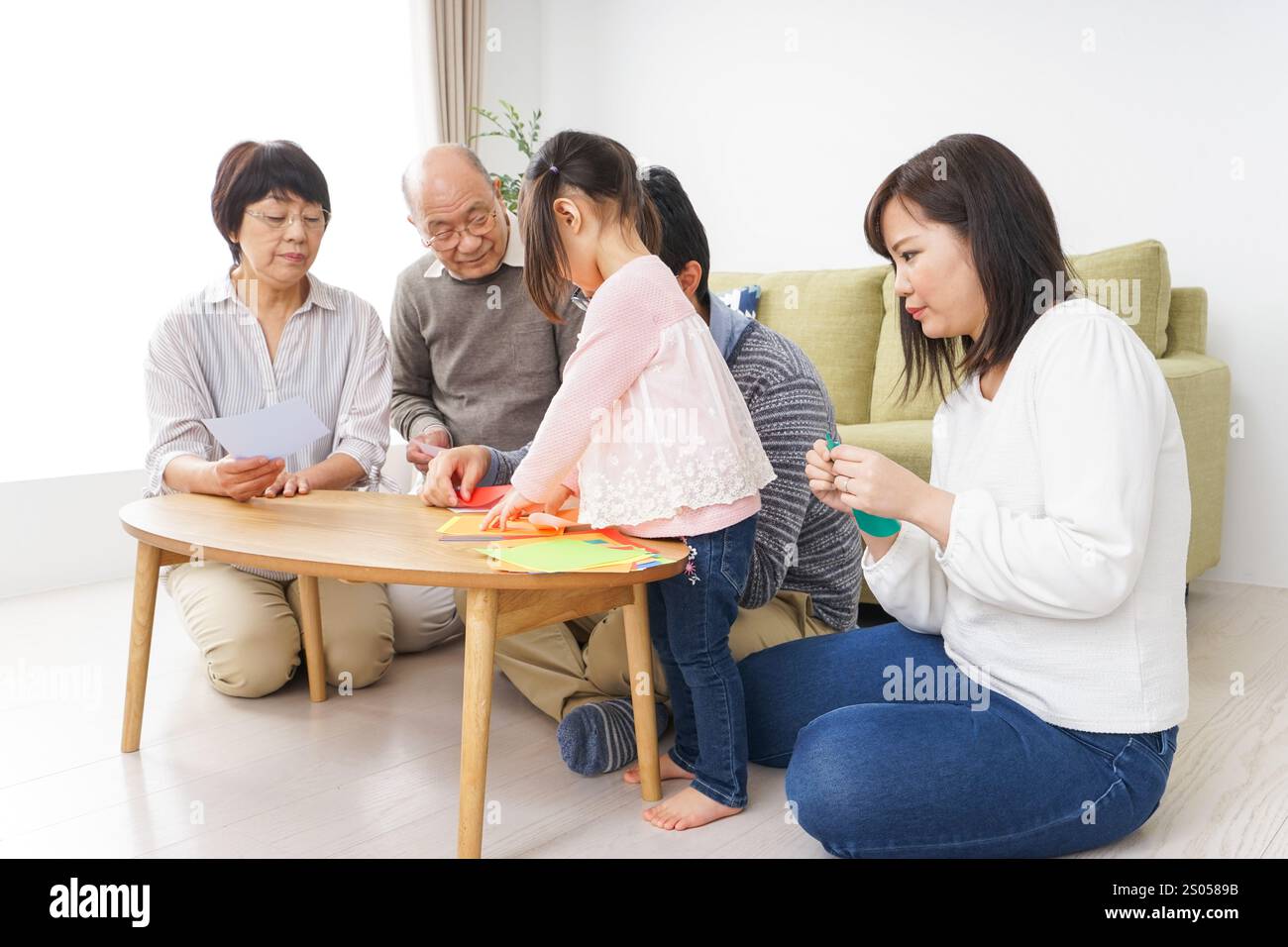 Children and family playing with origami Stock Photo - Alamy