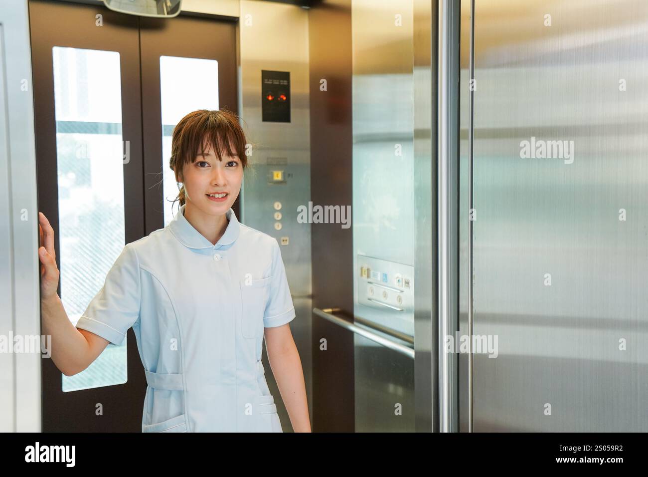 Nurse riding in lift Stock Photo - Alamy