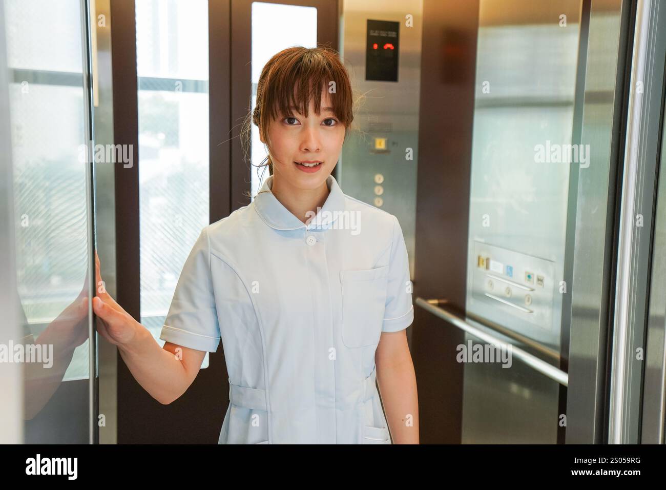 Nurse riding in lift Stock Photo - Alamy