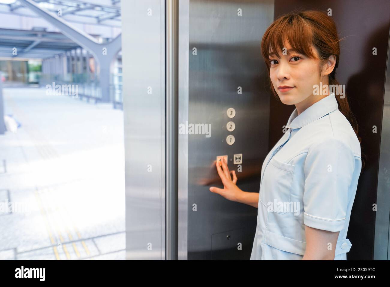 Nurse riding in lift Stock Photo - Alamy