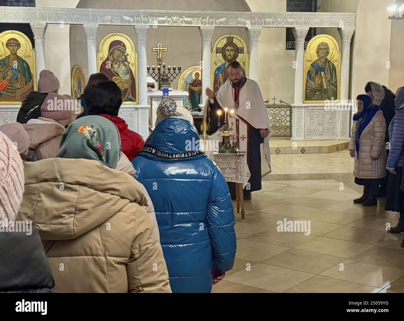 People attend a Christmas Eve church service in Bucha, near the ...