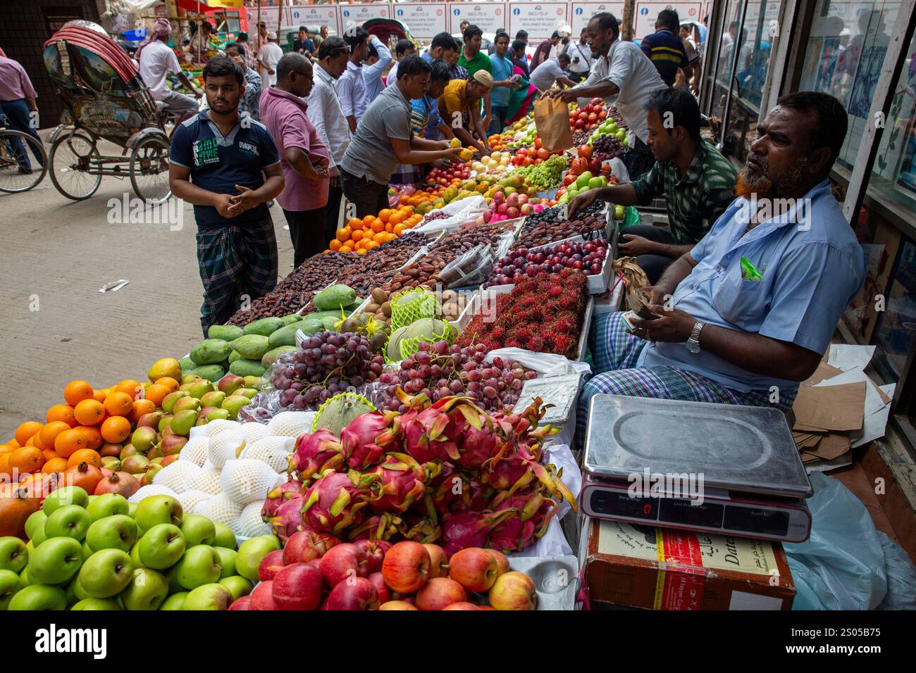 Customers gather at roadside fruit shops in Purana Paltan, Dhaka, where ...