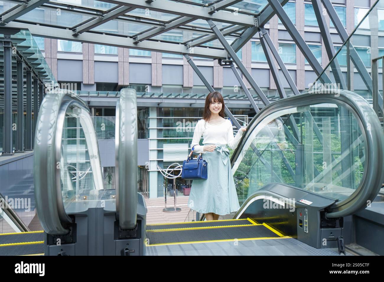 Woman riding escalator Stock Photo - Alamy