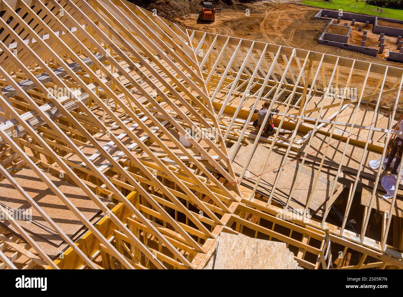 Workers are framing roof using wooden materials at busy construction site in work area Stock ...