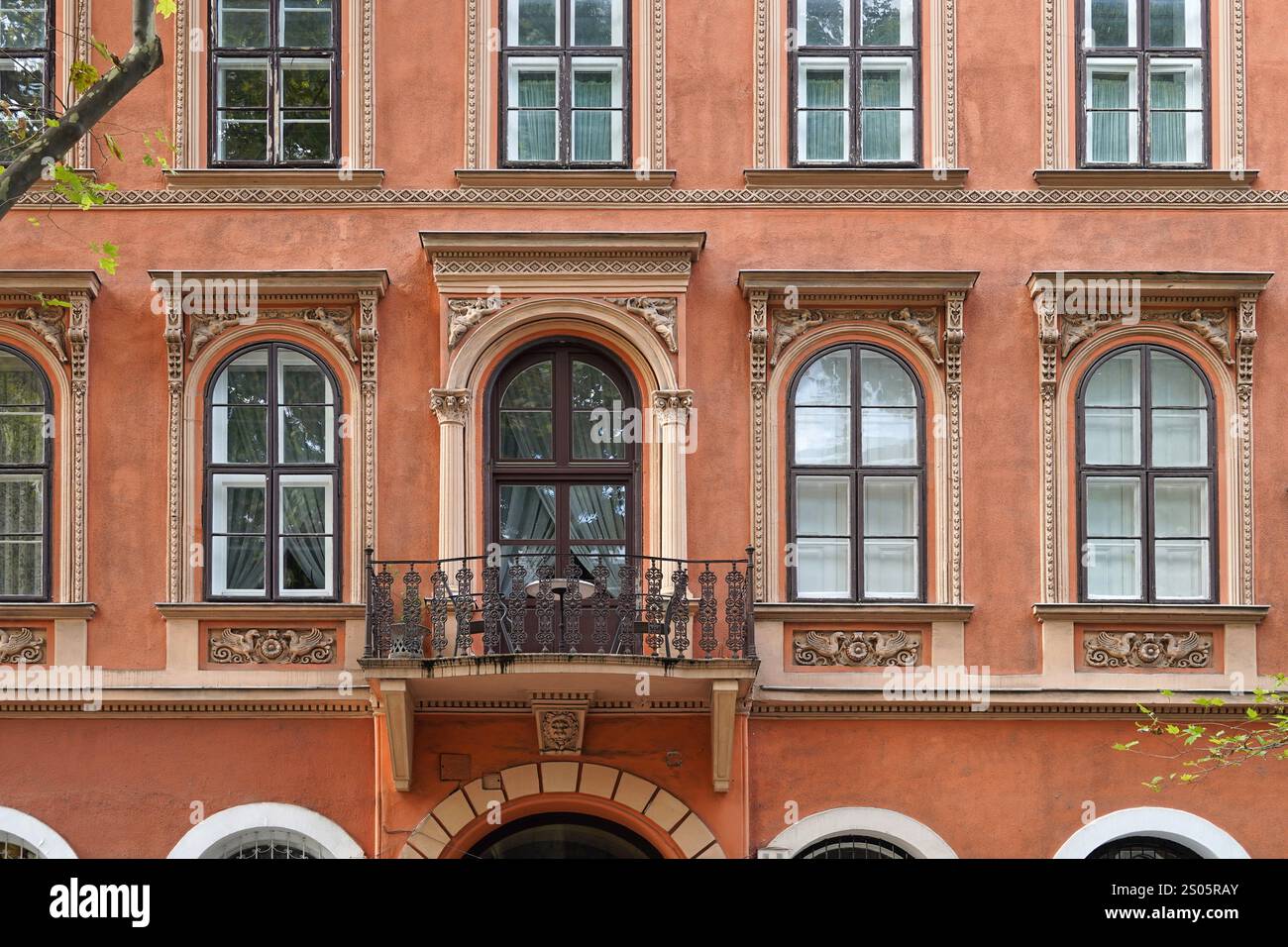 Facade of colorful stucco apartment building with ornate window frame ...