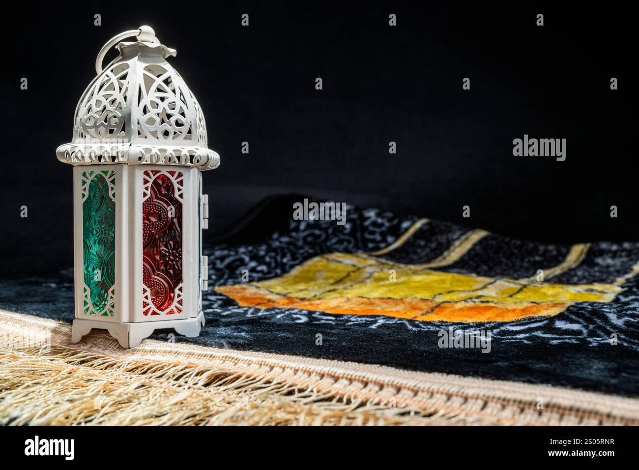Arabic lantern on a prayer mat with a black background. Decoration for ...