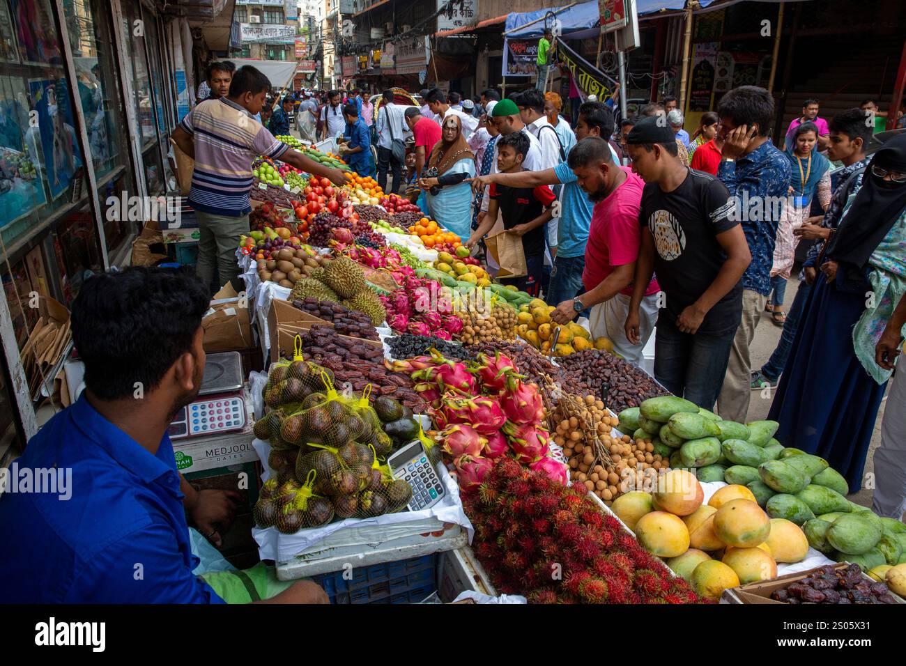 Customers gather at roadside fruit shops in Purana Paltan, Dhaka, where a variety of imported ...