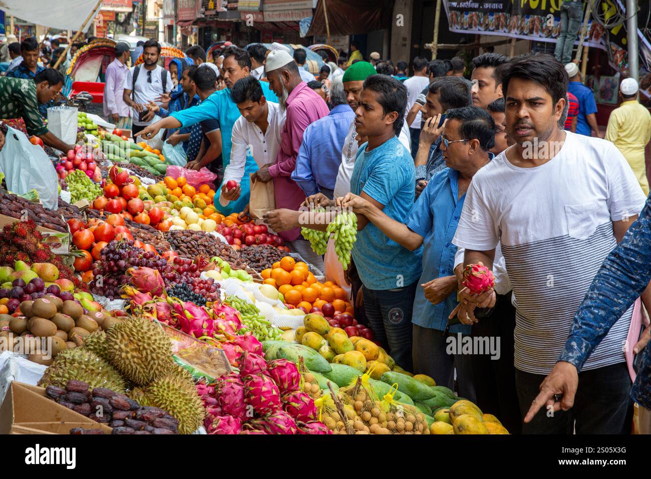 Customers gather at roadside fruit shops in Purana Paltan, Dhaka, where a variety of imported ...