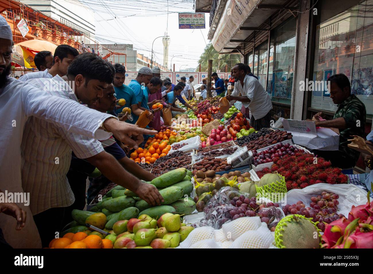 Customers gather at roadside fruit shops in Purana Paltan, Dhaka, where a variety of imported ...