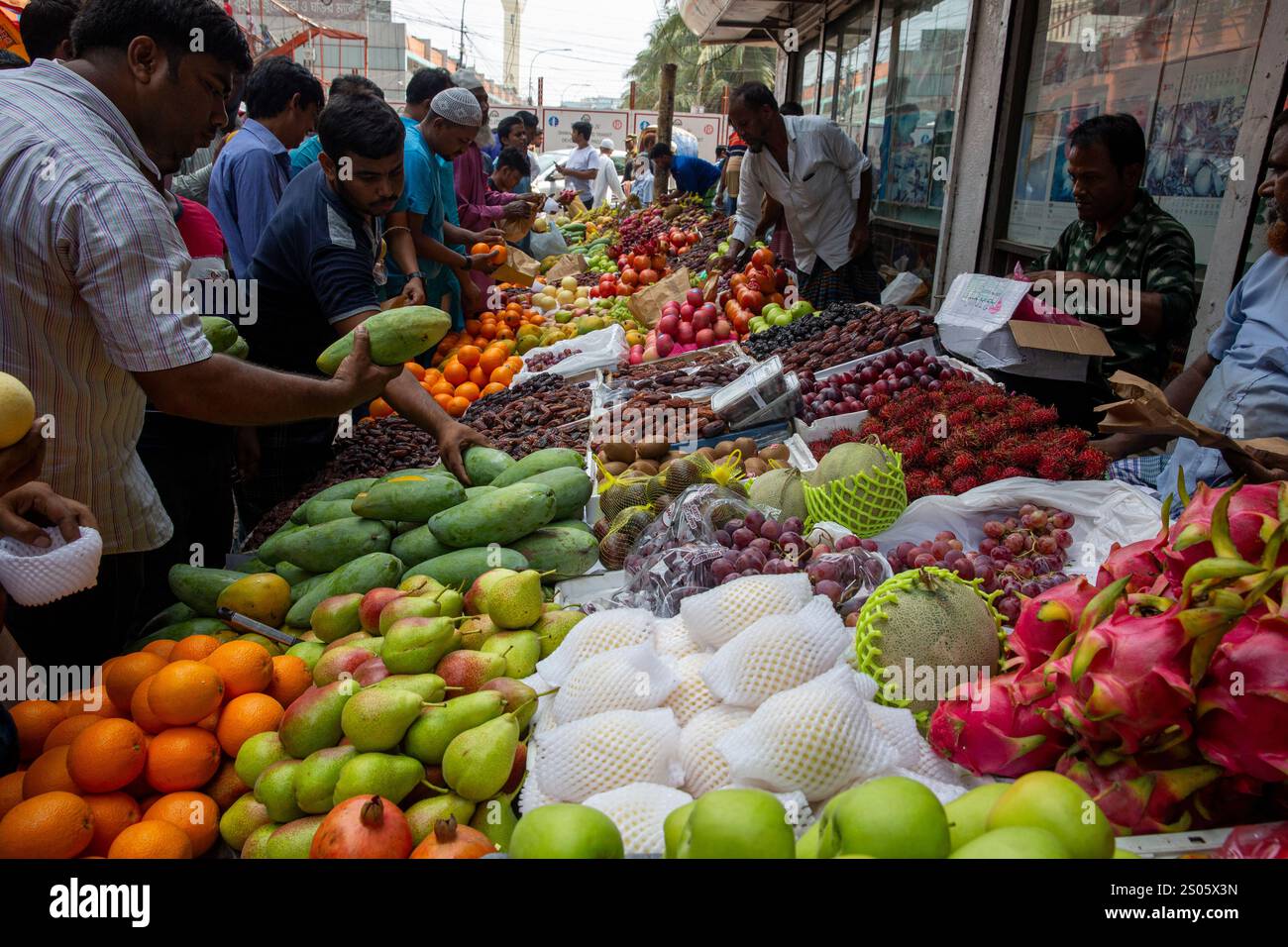 Customers gather at roadside fruit shops in Purana Paltan, Dhaka, where a variety of imported ...
