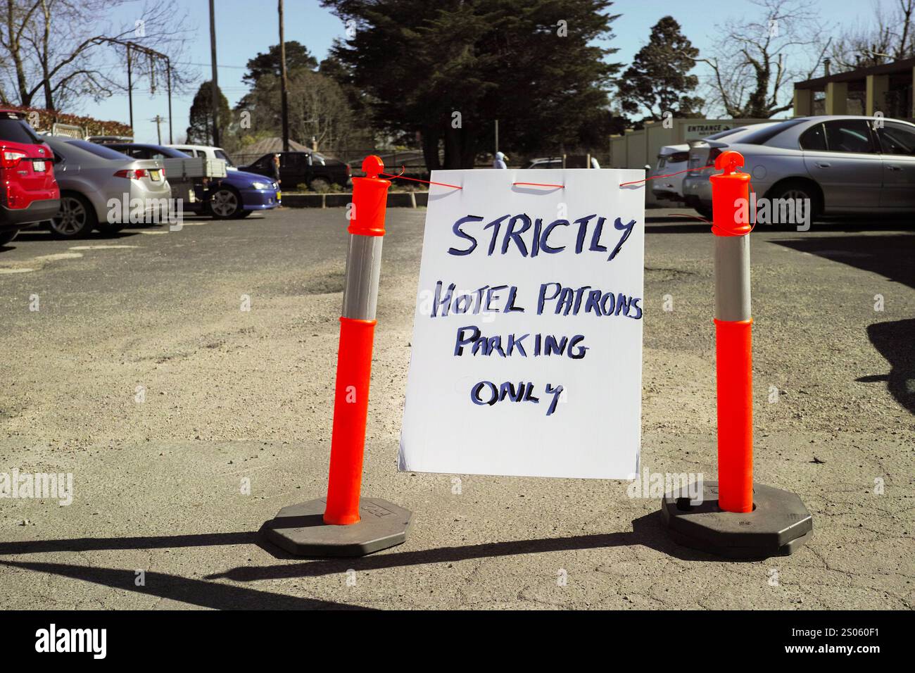 A hand-written sign reading "Strictly Hotel Patrons Parking Only ...