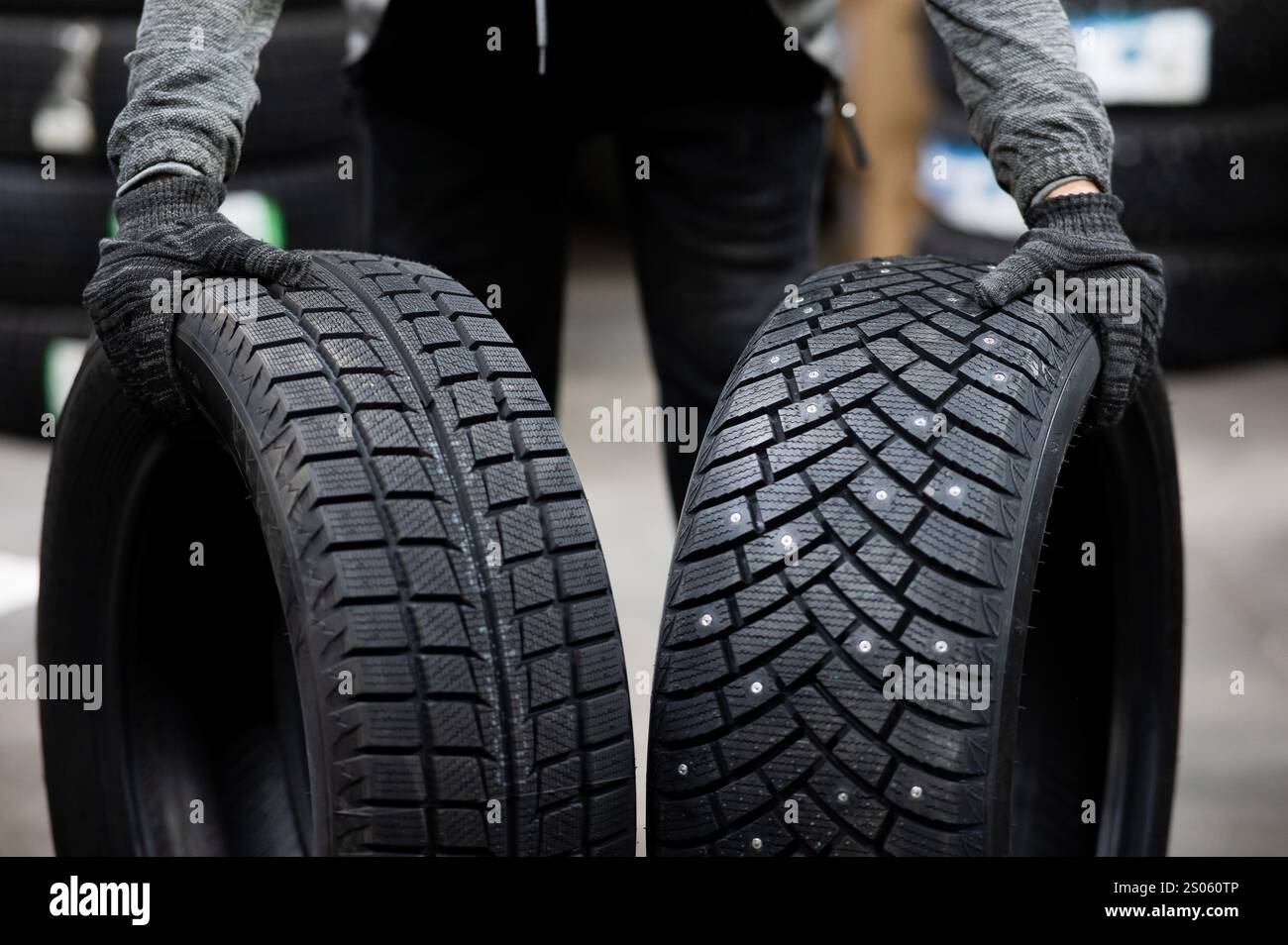 Mechanic keeps new summer and winter car tires in the garage. Comparison of wheels for different ...