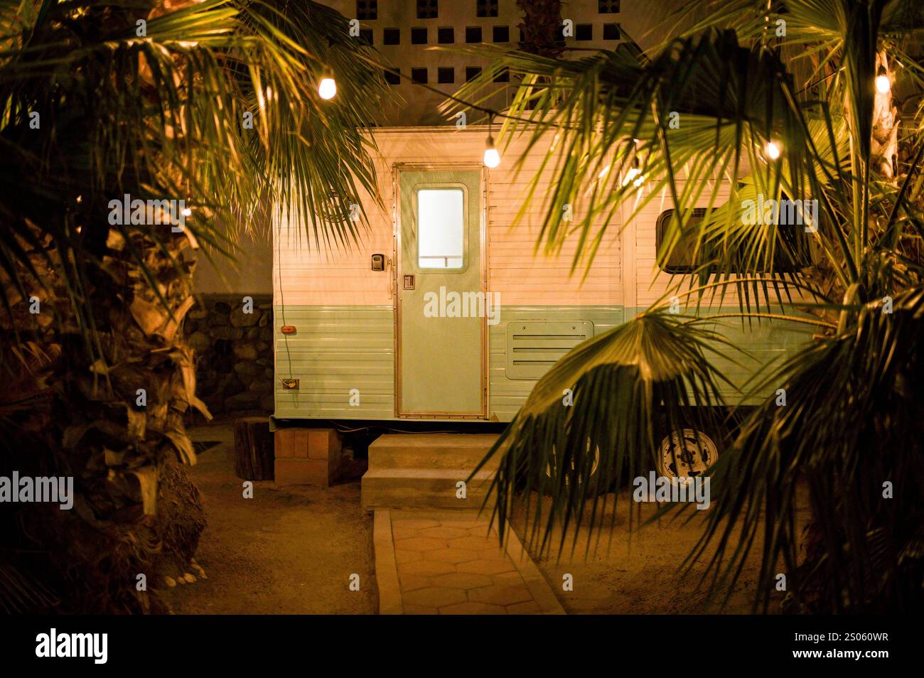 Photo of an older, rustic turquoise and white small RV trailer with ...