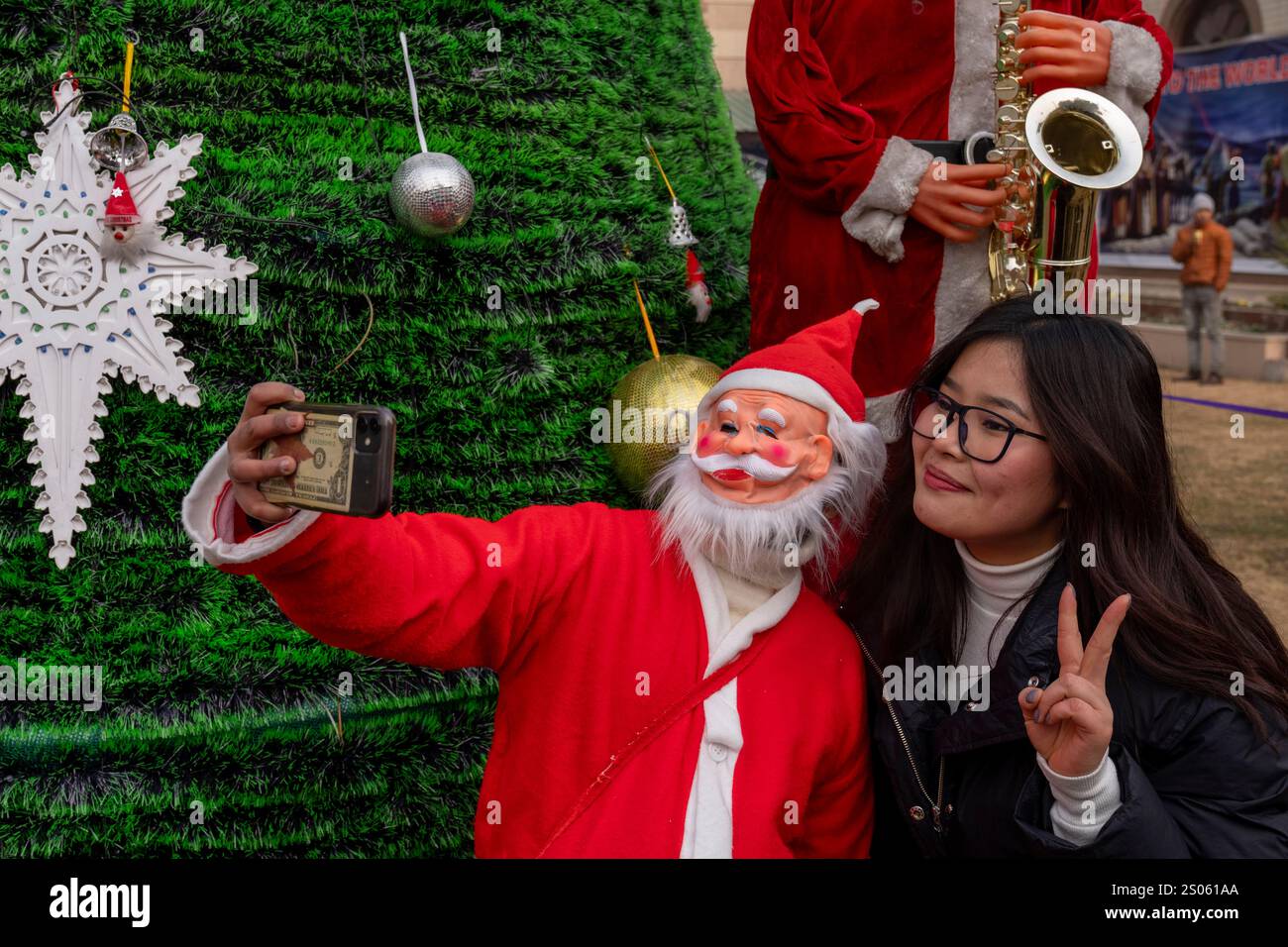 A Christian devotee poses for picture with a boy dressed as Santa Claus ...