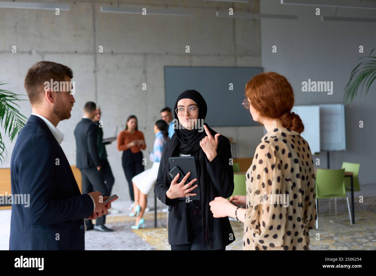 A diverse group of business professionals engages in a conversation ...