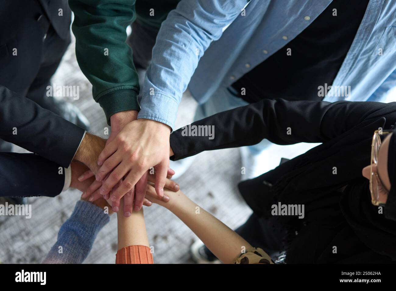 A top view of business people joining hands in a circle, symbolizing ...
