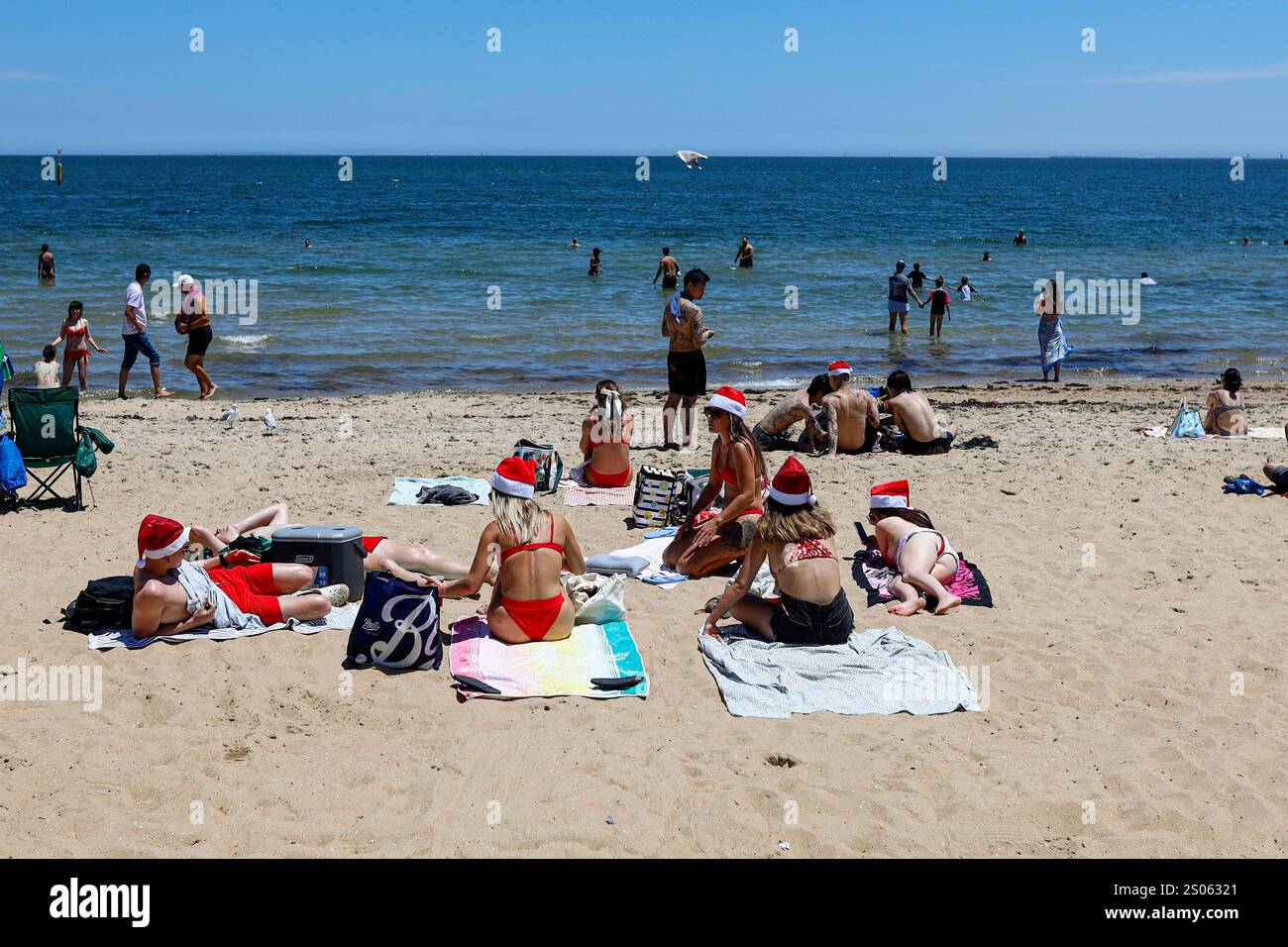 Melbourne, Australia. 25th Dec, 2024. Crowds celebrate a summer Christmas at St Kilda Beach ...