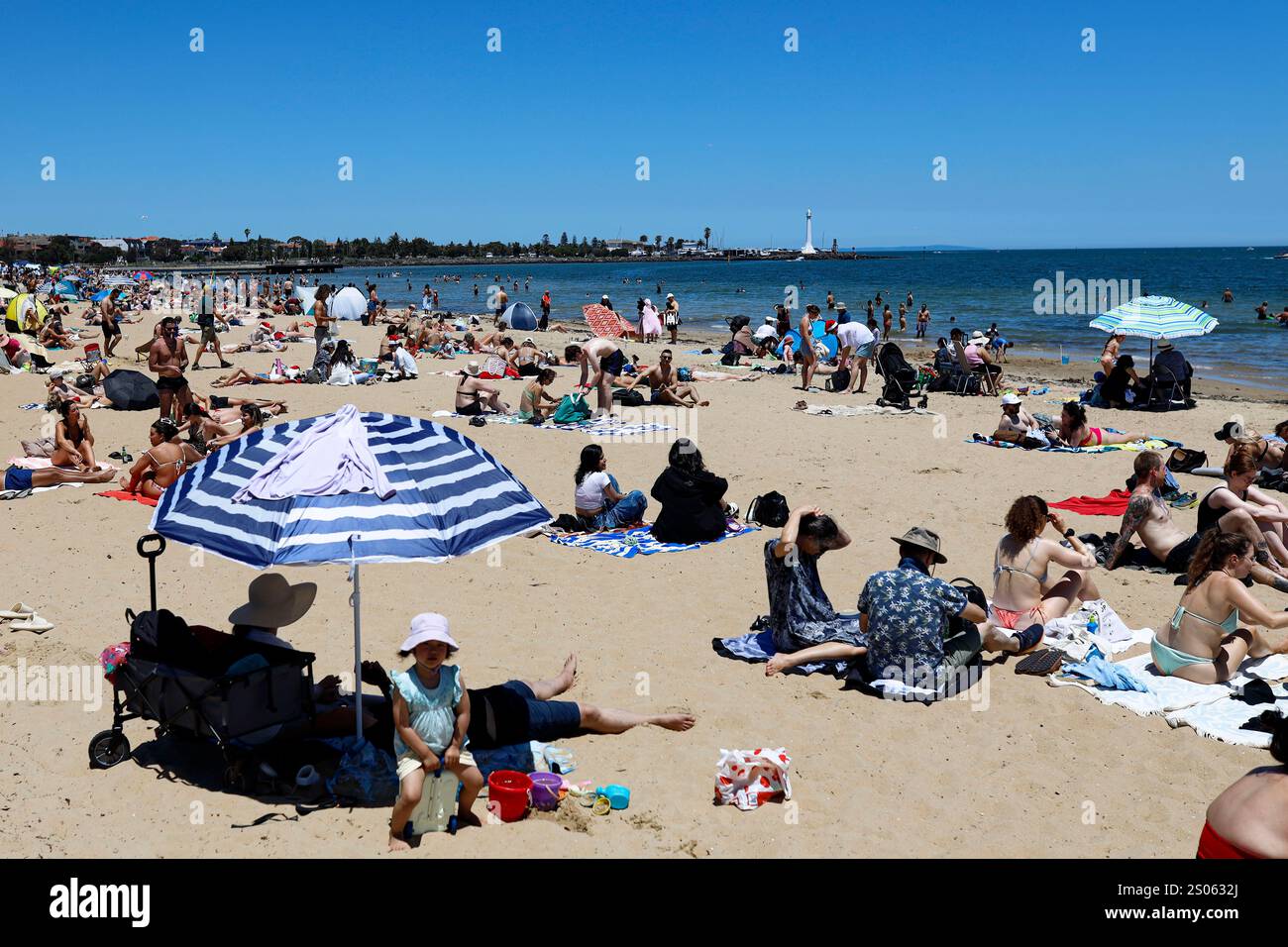 Melbourne, Australia. 25th Dec, 2024. Crowds celebrate a summer Christmas at St Kilda Beach ...