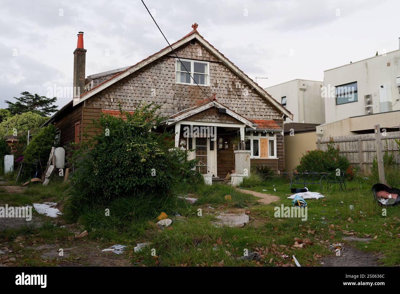 Front yard and exterior of an unkempt and decaying suburban home, with ...