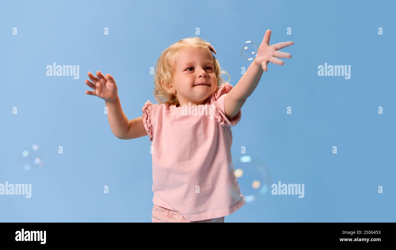 Happy little child, smiling girl clapping hands happily while catching ...