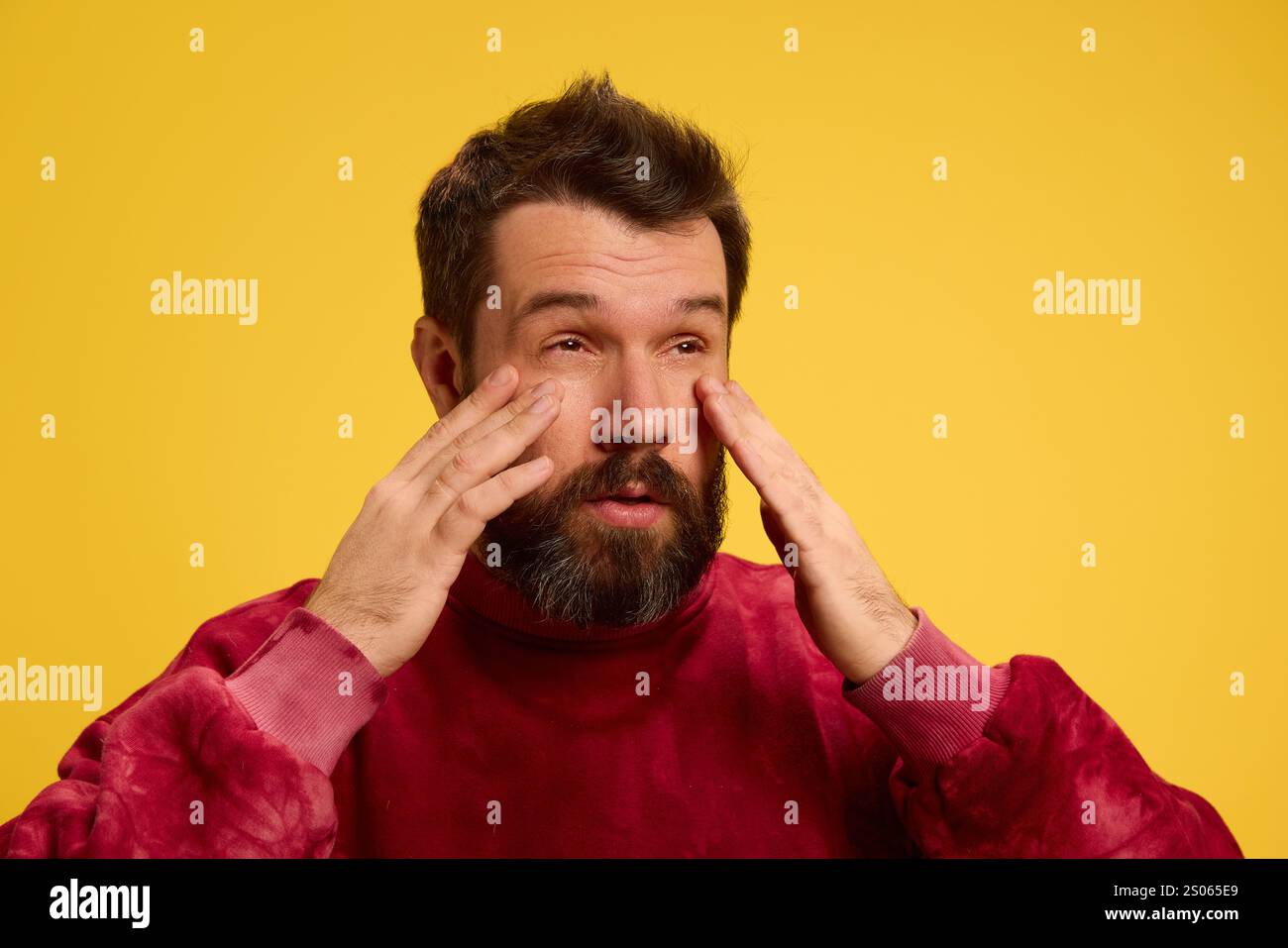 Close-up photo of young man dressed casual attire touching his eyes ...