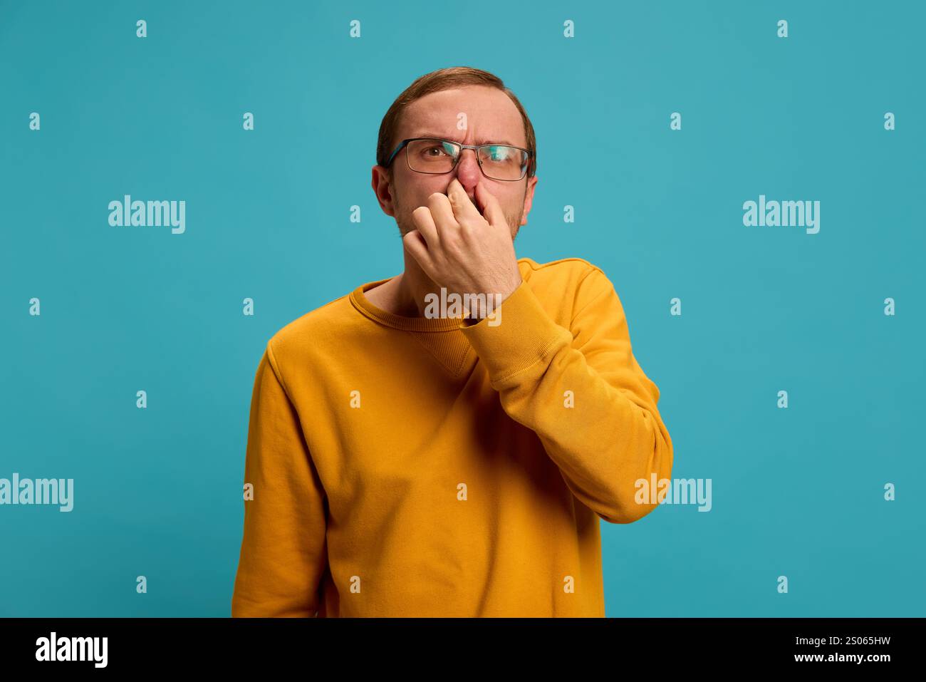 Young man with red nose suffers from allergies and rhinitis against ...