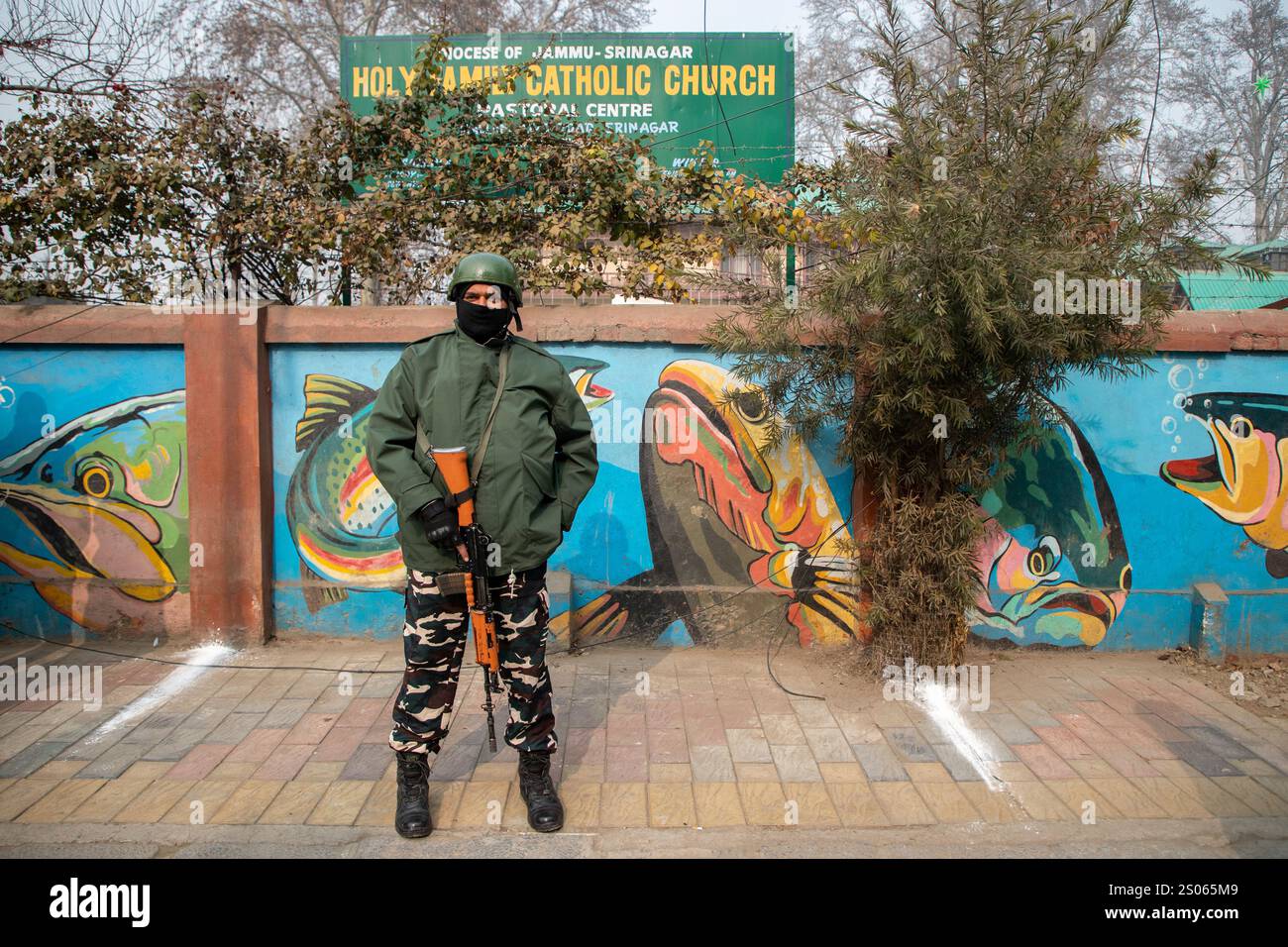 An Indian paramilitary soldier stands guard as Christians attend ...