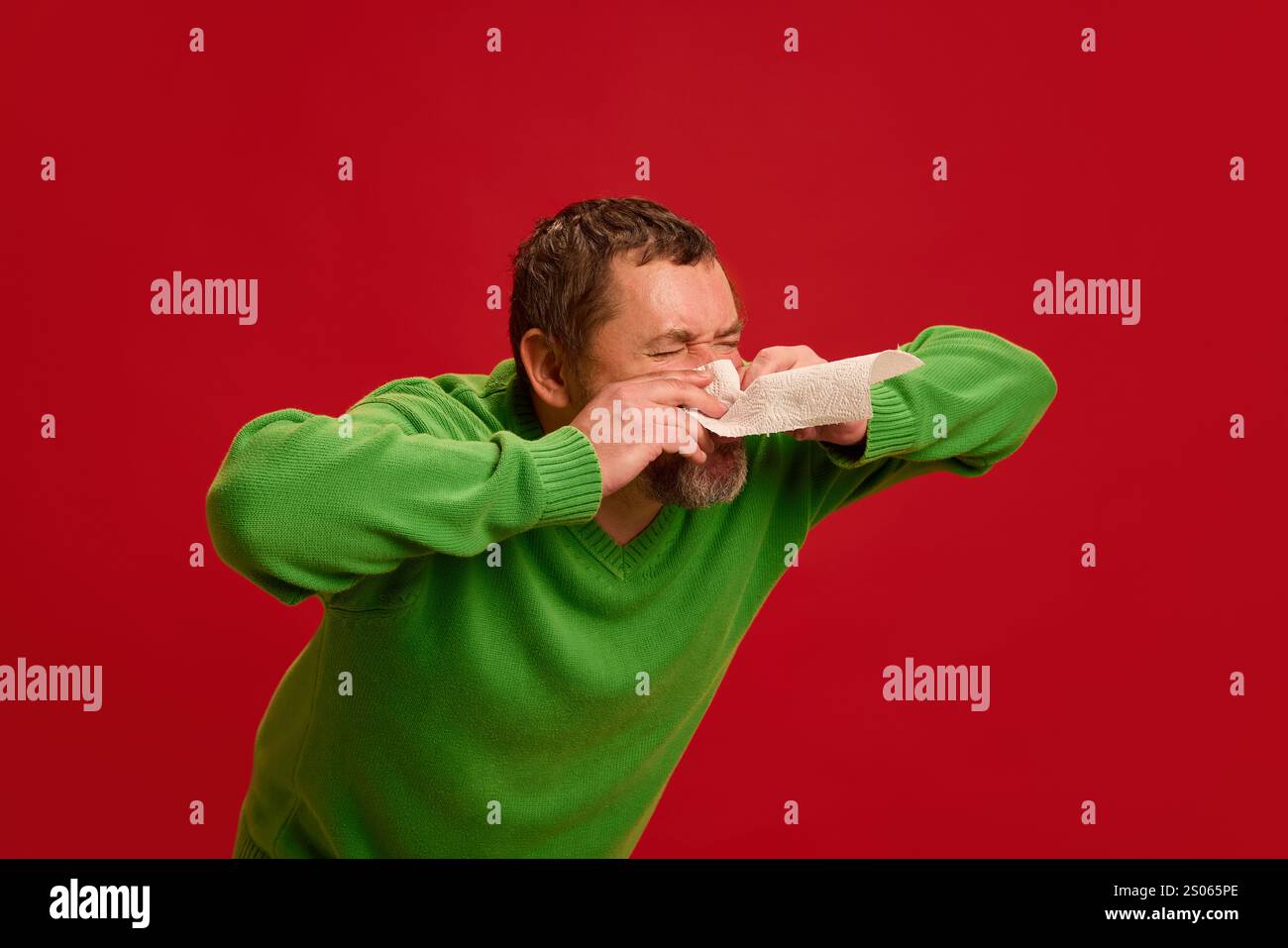 Man sneezing into tissue, face strained, highlighting flu virus spread ...