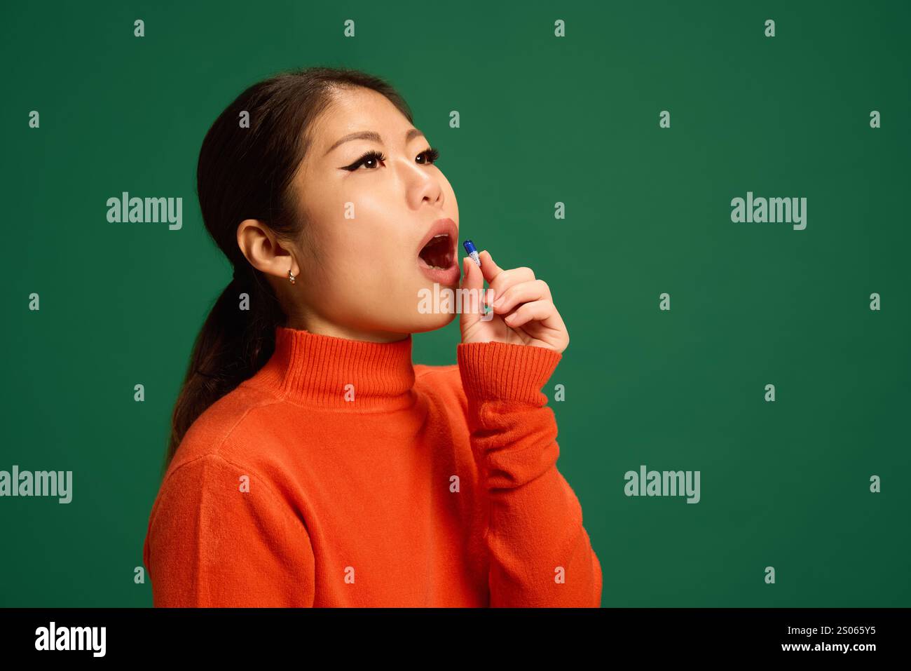 Woman preparing to take capsule for viral infection or illness relief ...